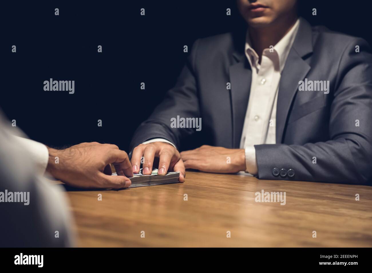 Dishonest businessman secretly giving money to his partner in the dark ...