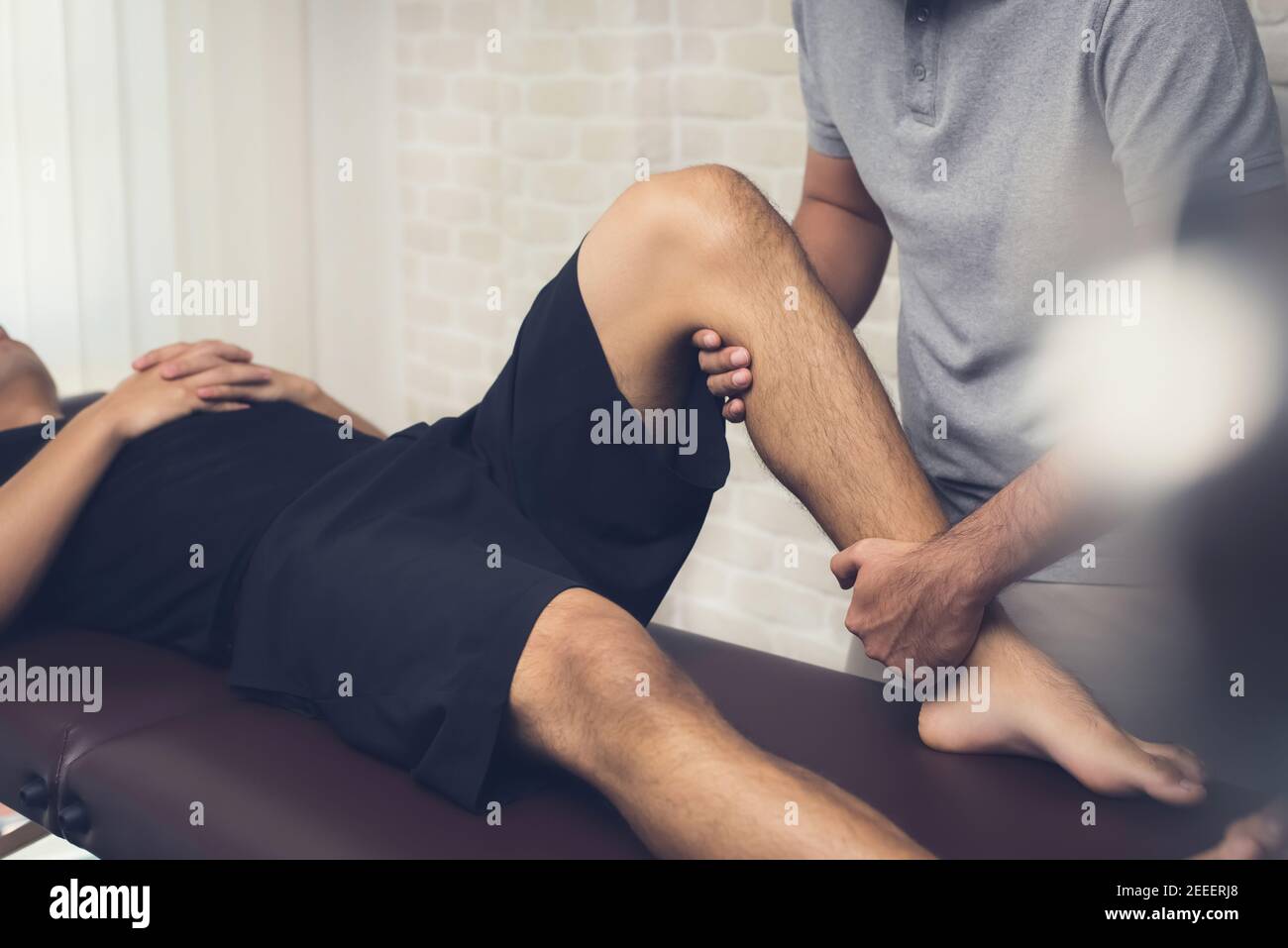 Male therapist giving leg massage to athlete patient - sport physical ...
