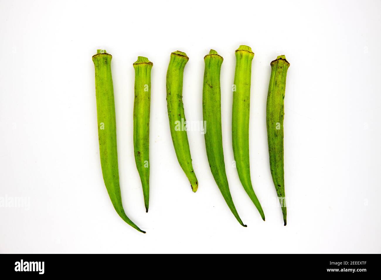 Green bamia in row on white background. Tropical vegetable top view ...