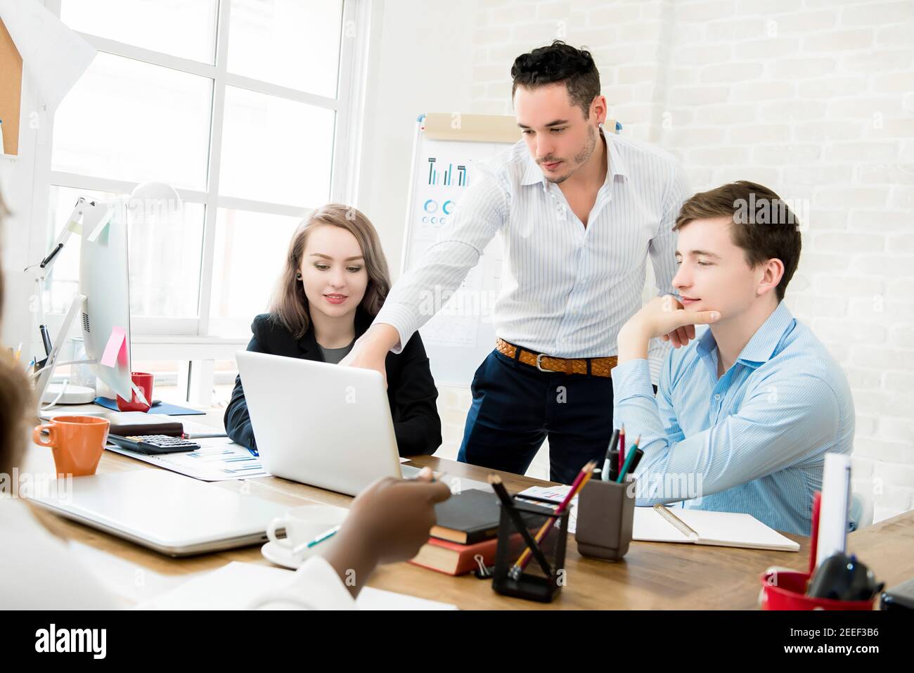 Group of business people looking at laptop computer screen discussing ...
