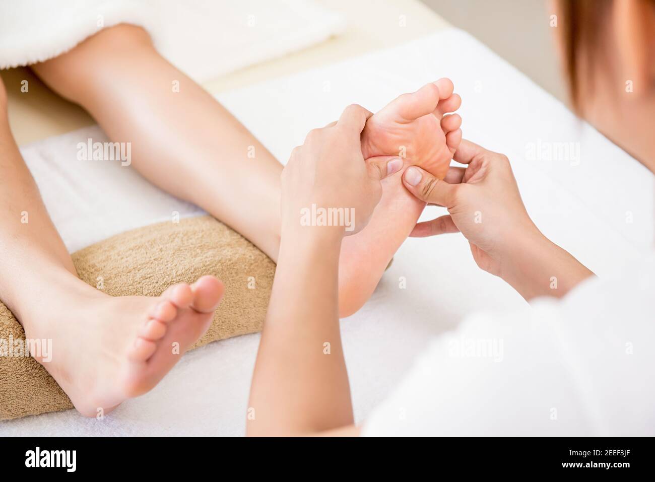 Professional Therapist Giving Traditional Thai Foot Massage To A Woman
