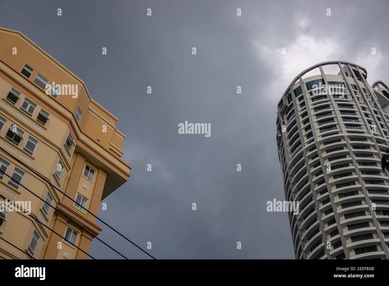 Tall building on stormy sky, view from ground. Office and living ...
