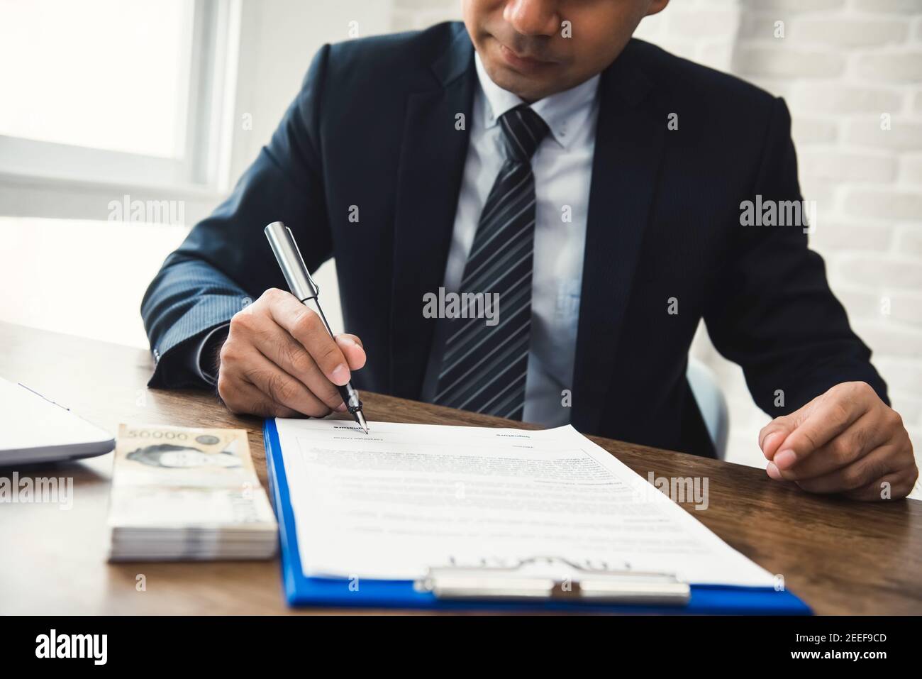 Businessman signing contract with money, South Korean Won banknotes, on ...