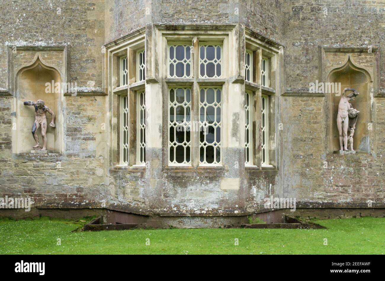 Classical statues inset into the wall on either side of a window ...