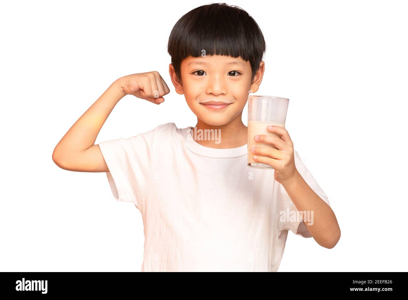 The Asian boy smiled happily, holding a glass of milk and acting like a ...