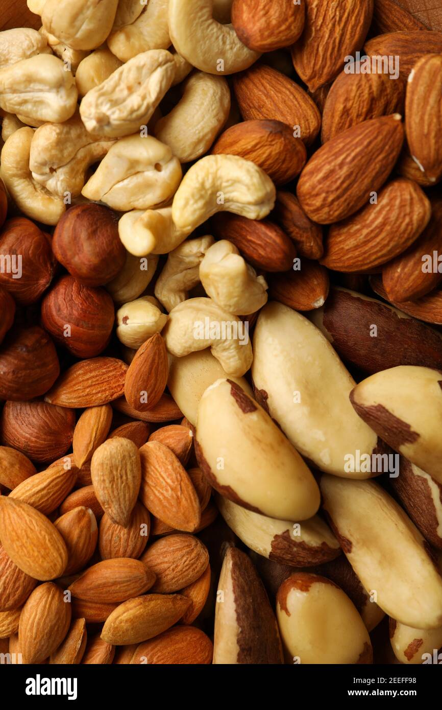 Different nuts on whole background, close up Stock Photo - Alamy