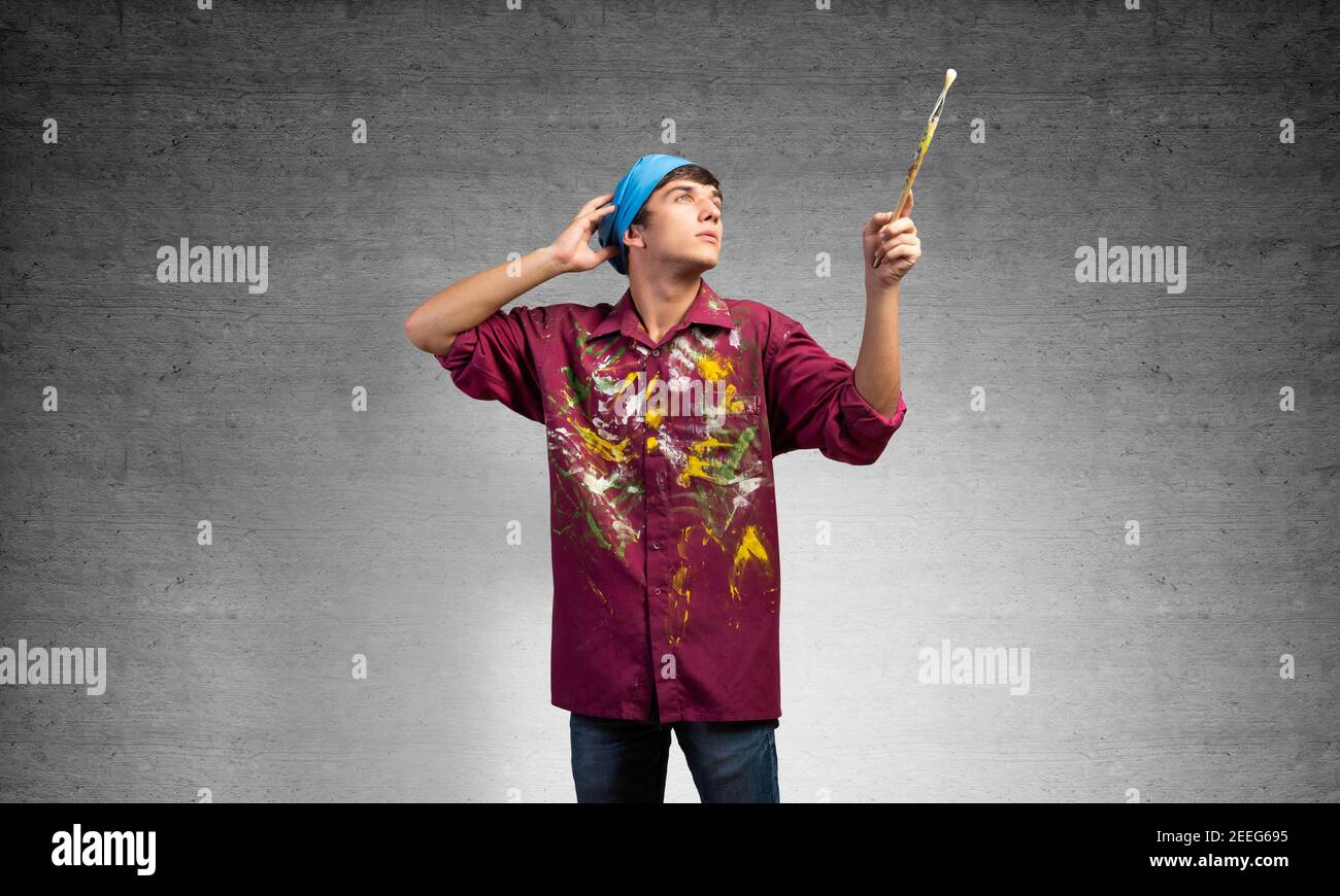 Young painter artist pointing upwards Stock Photo - Alamy