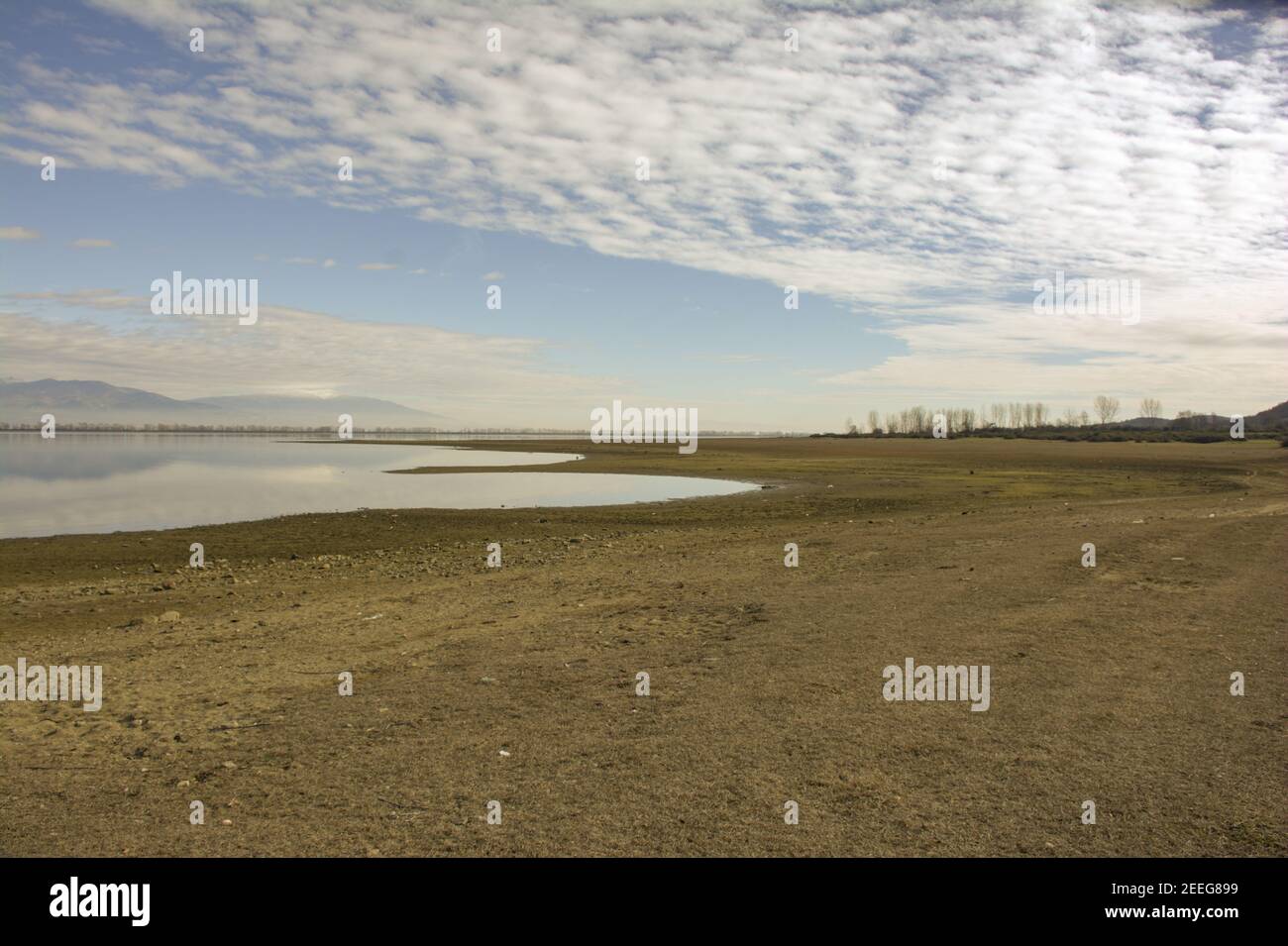 Empty bay of a lake reflecting the cloudy sky Stock Photo - Alamy