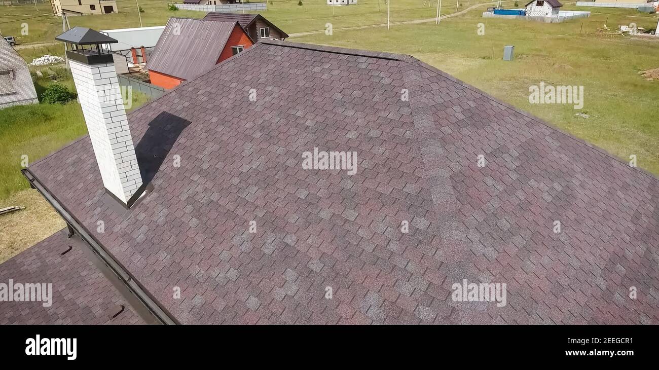 House with a roof from a bituminous tile. Bituminous tile for a roof. a ...