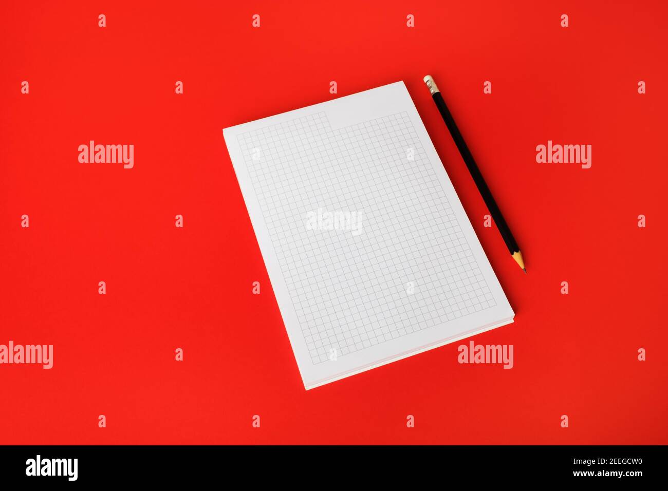 Blank copybook and pencil on red paper background. Blank branding ...