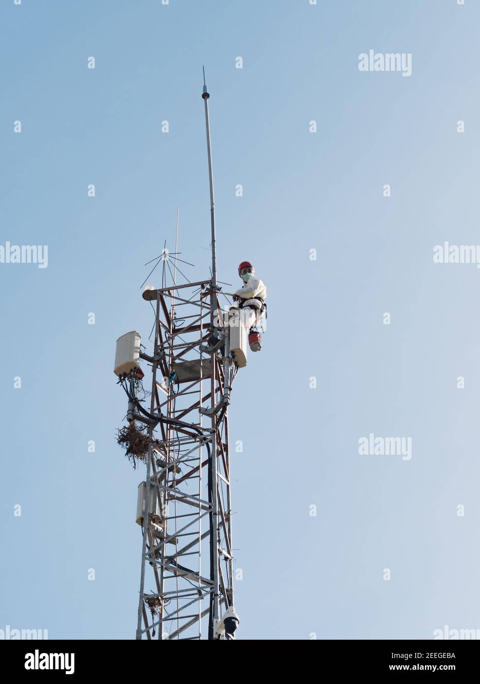 Concept: vertical work. Two technicians working on a tall and dangerous ...