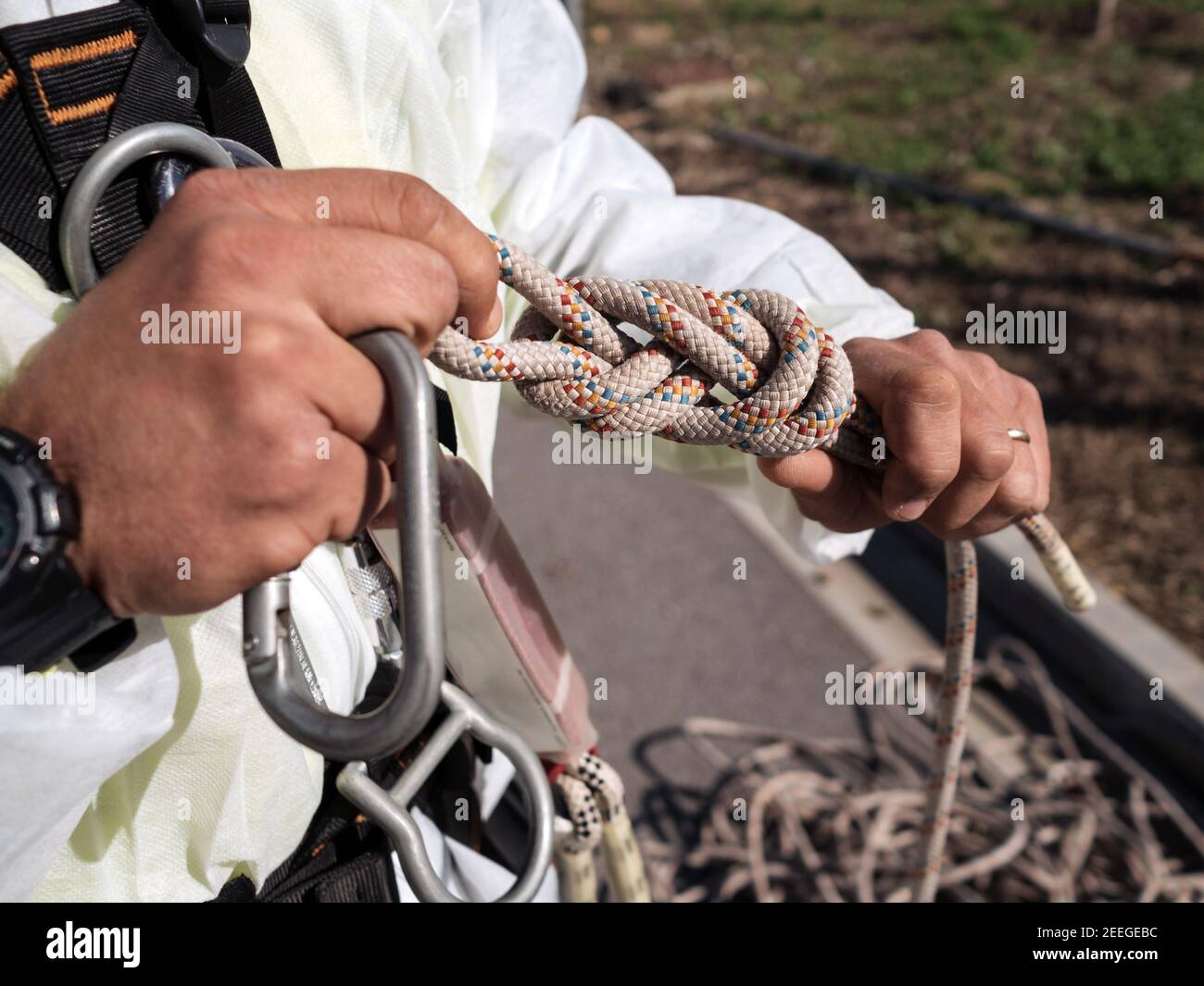 Concept: vertical climbing work. Detail of hands making an eight knot ...