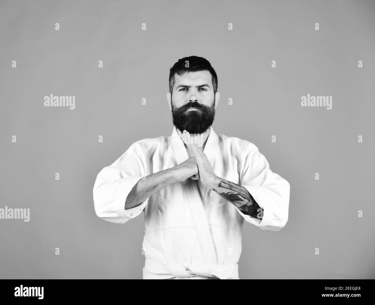 Karate man with serious face in uniform. Man with beard in white kimono ...