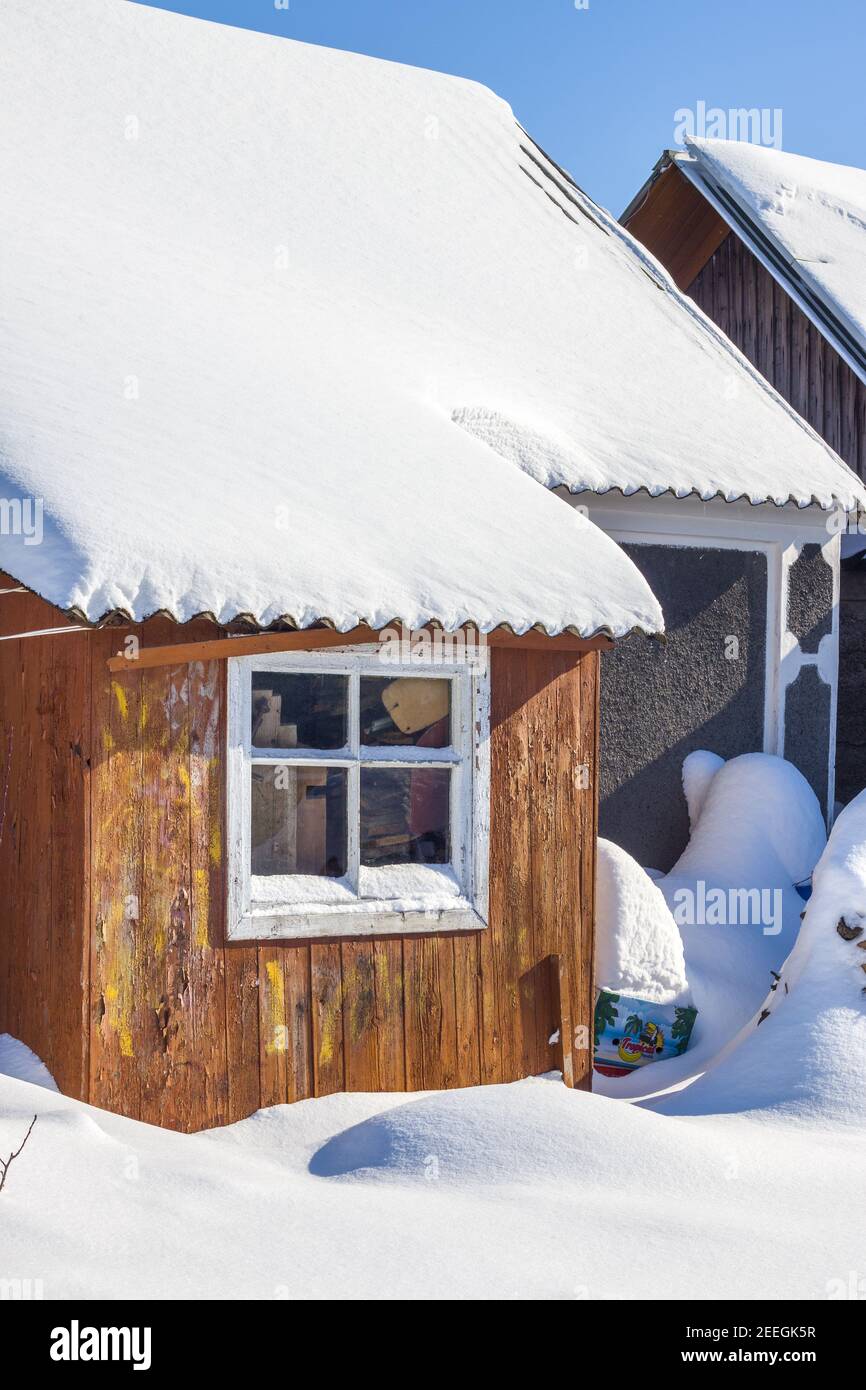 Winter snow covered old house. Fresh snowdrift and retro home backdrop ...