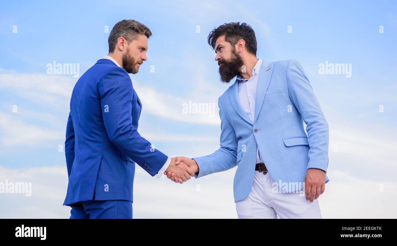 Sure sign you should trust business partner. Men formal suits shaking ...