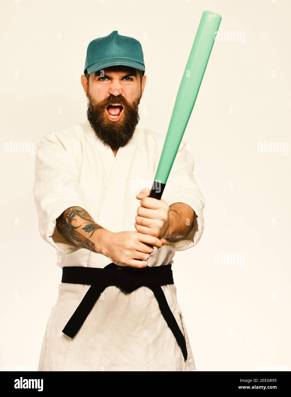 Karate man with raging face holds green baseball bat. Man with beard in ...
