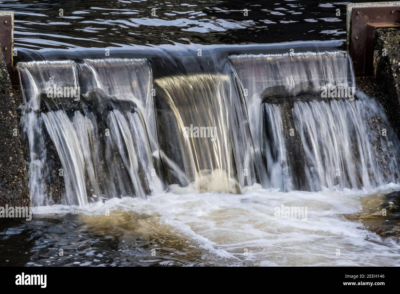 Water flowing over a small weir on a river Stock Photo - Alamy