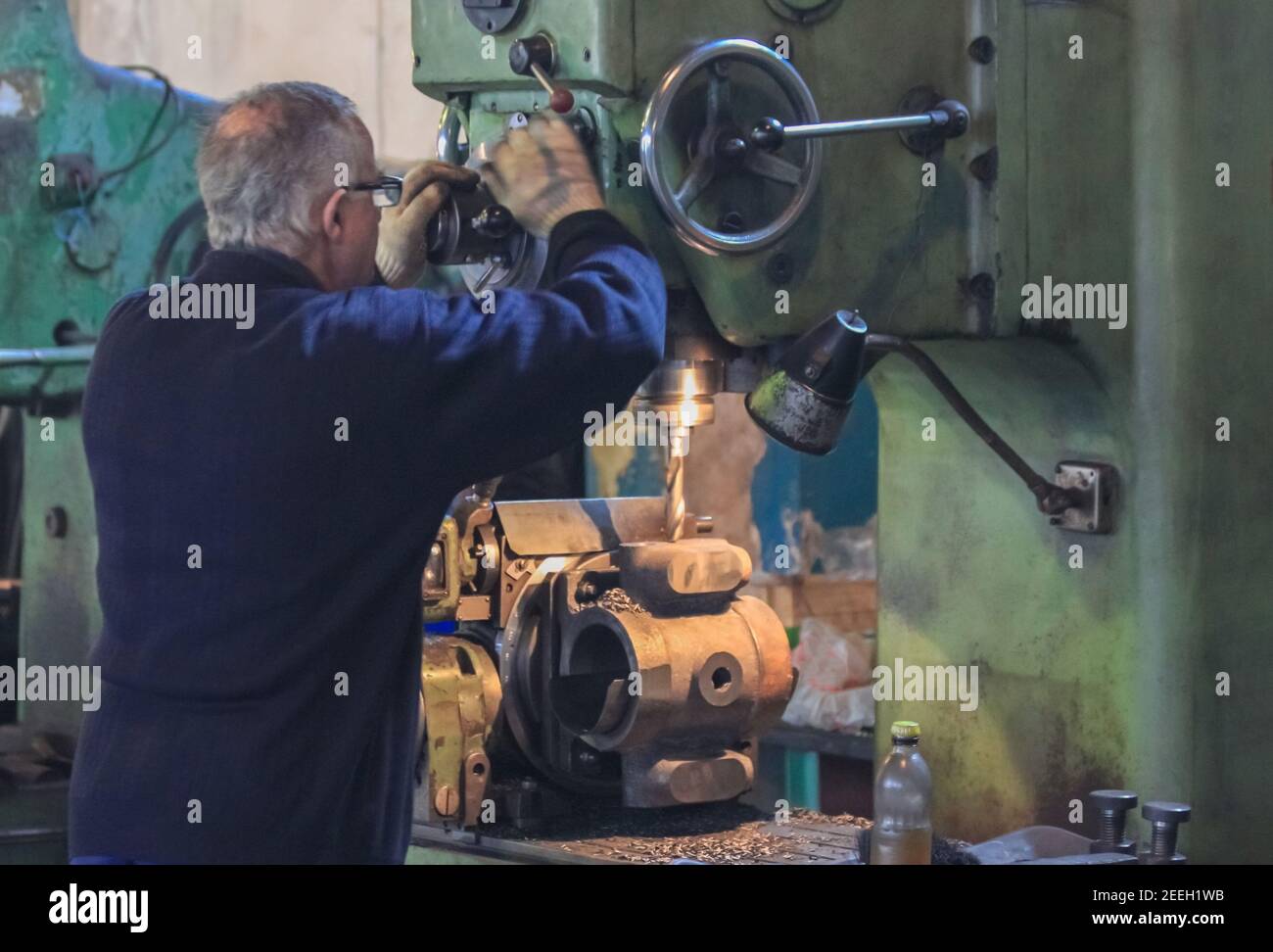 A man works on an industrial drilling machine Stock Photo - Alamy