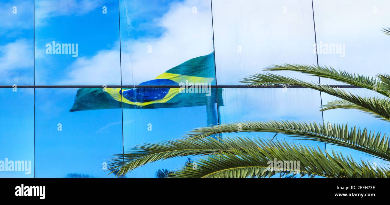Reflection of the flag of Brazil in glass facade of a building with ...