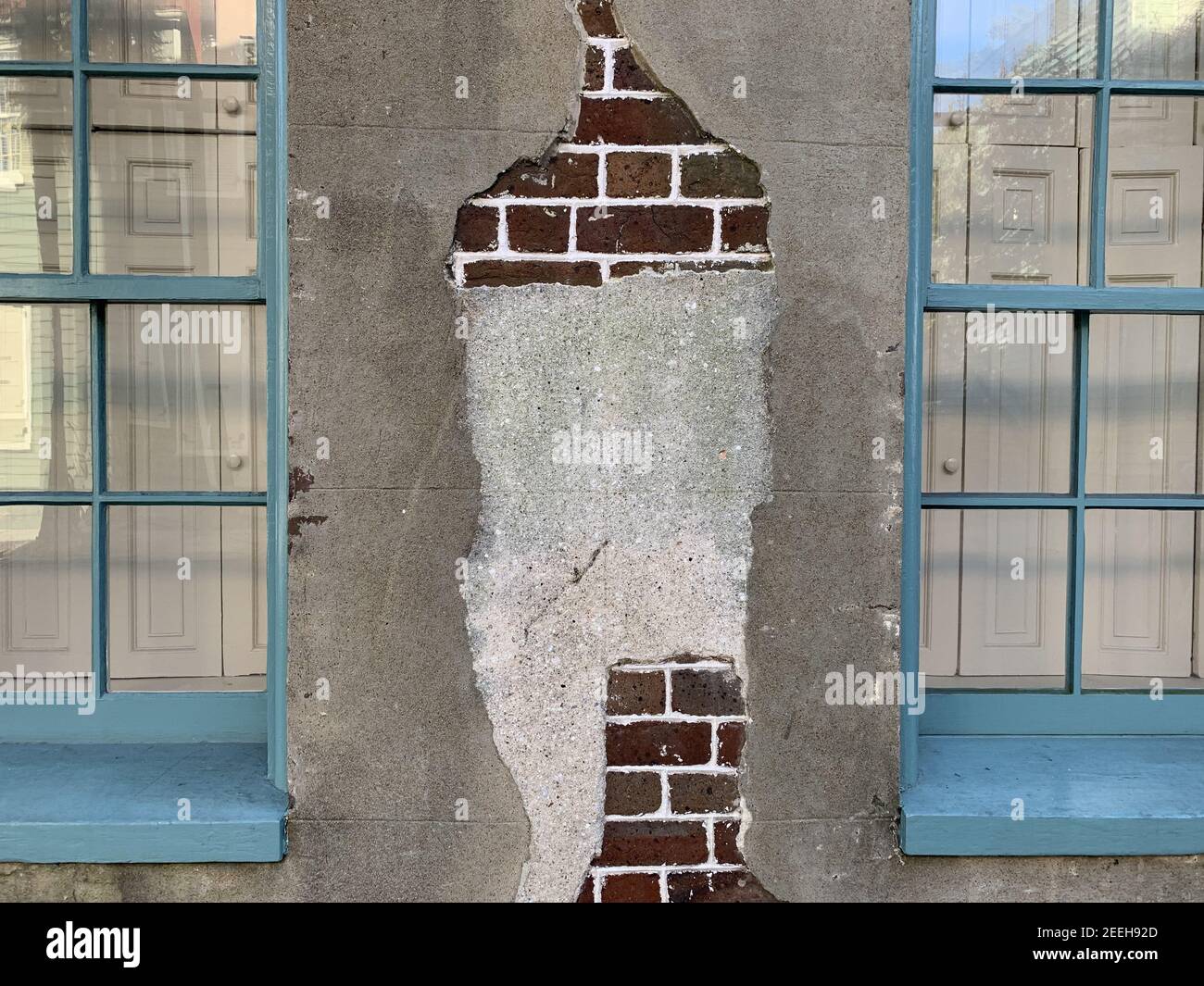 Closeup shot of an exposed brick wall texture between two windows Stock ...