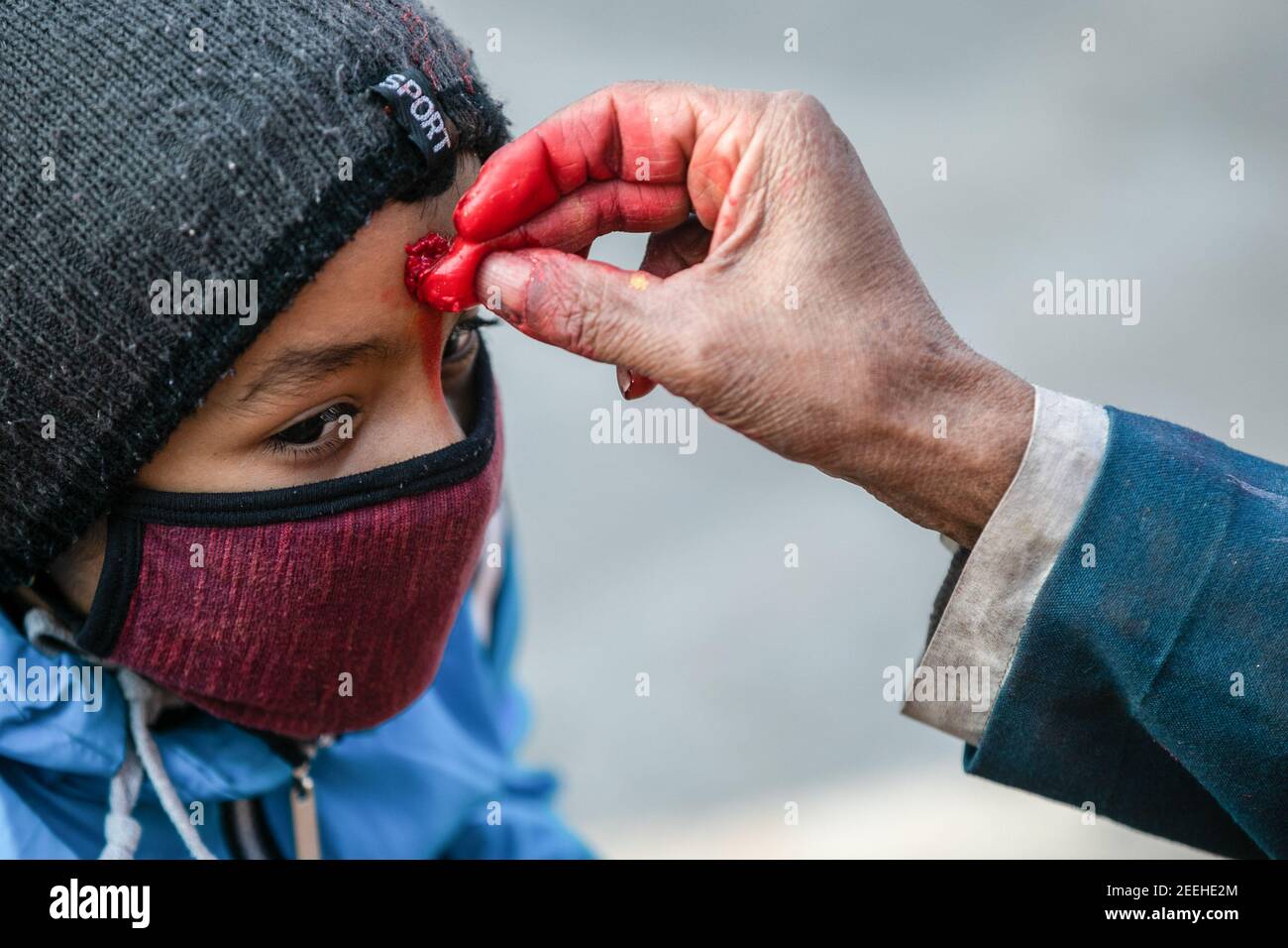 Kathmandu, Nepal. 16th Feb, 2021. A man applying "Tika" on the forehead ...
