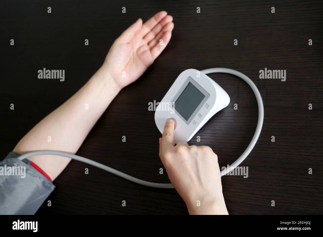 Female hand with blood pressure monitor, woman measuring the pressure ...