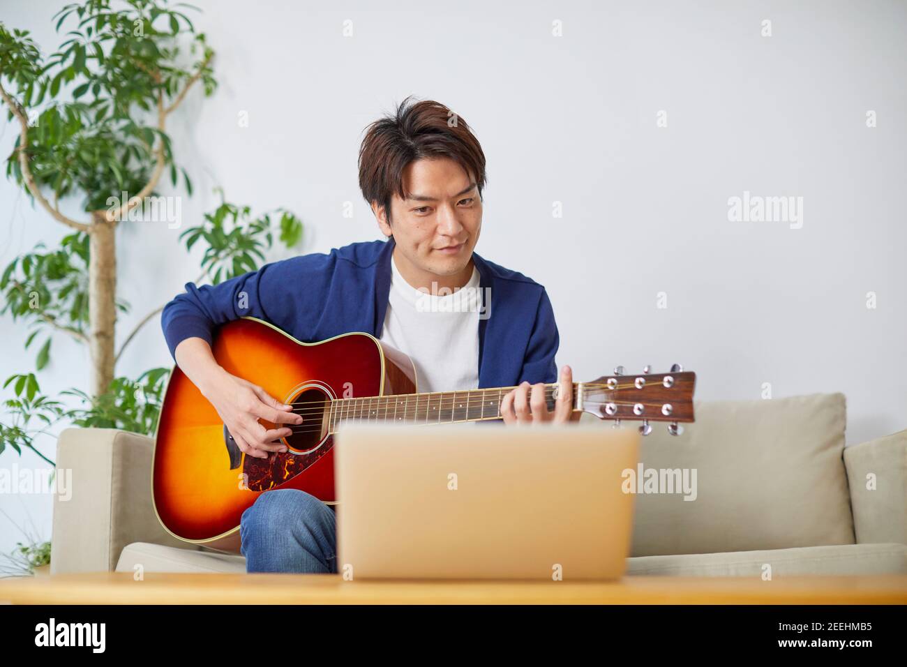 Japanese man playing guitar at home Stock Photo - Alamy