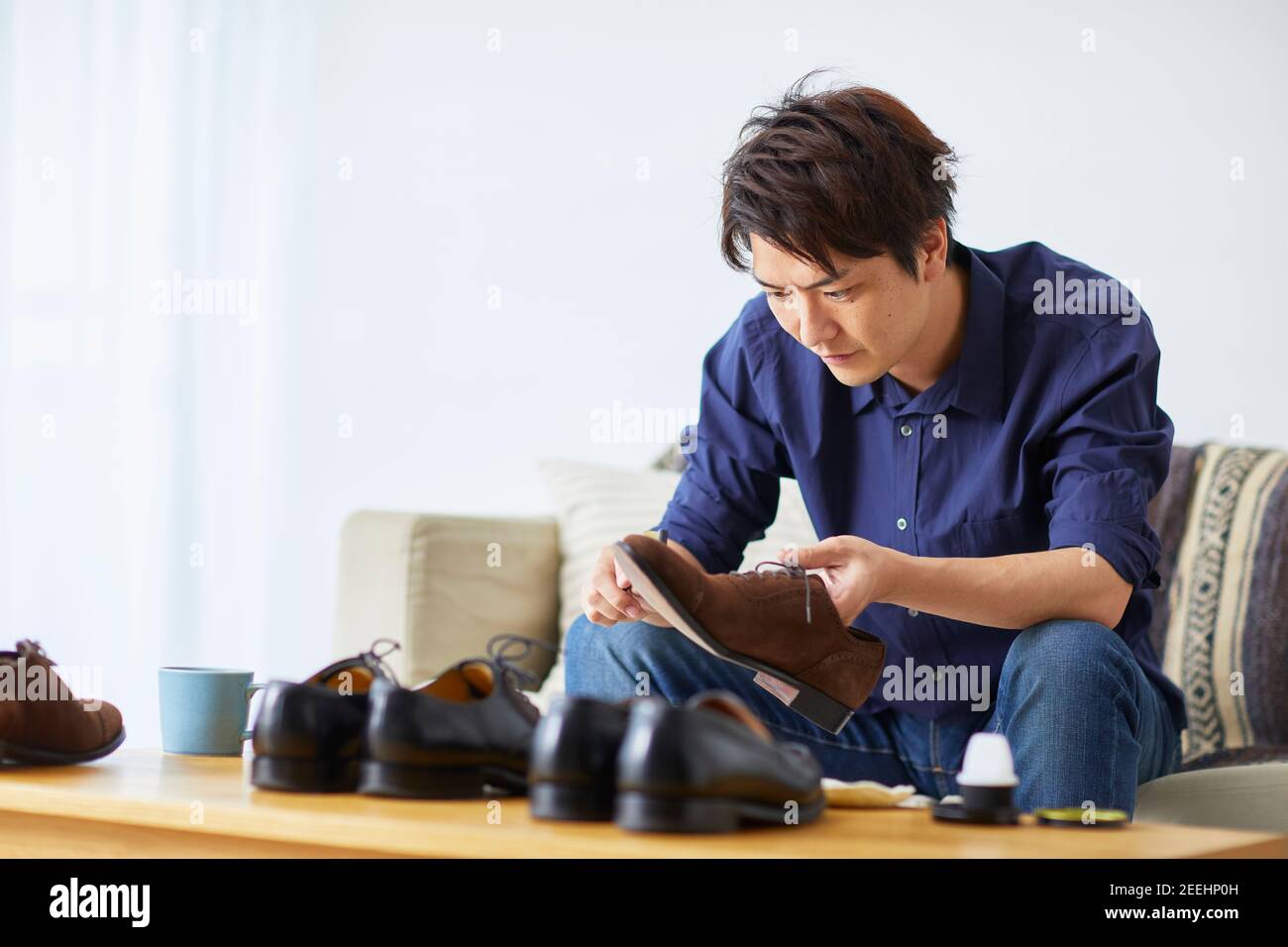Japanese man cleaning shoes at home Stock Photo - Alamy