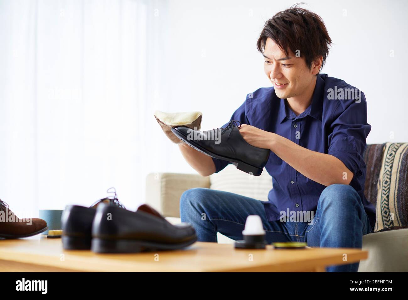 Japanese man cleaning shoes at home Stock Photo - Alamy