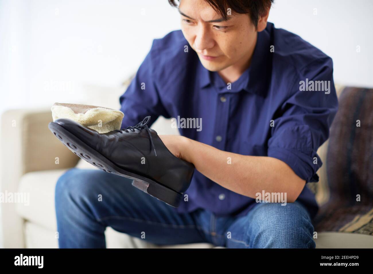 Japanese man cleaning shoes at home Stock Photo - Alamy