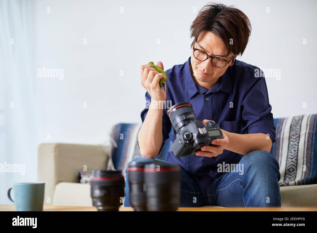 Japanese man cleaning camera at home Stock Photo - Alamy
