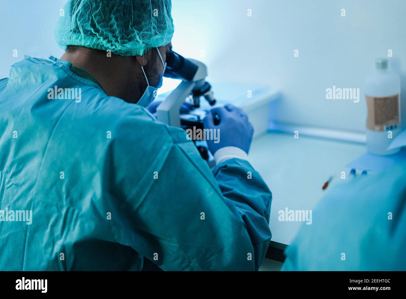 Medical scientists working inside laboratory with microscope - Focus on ...