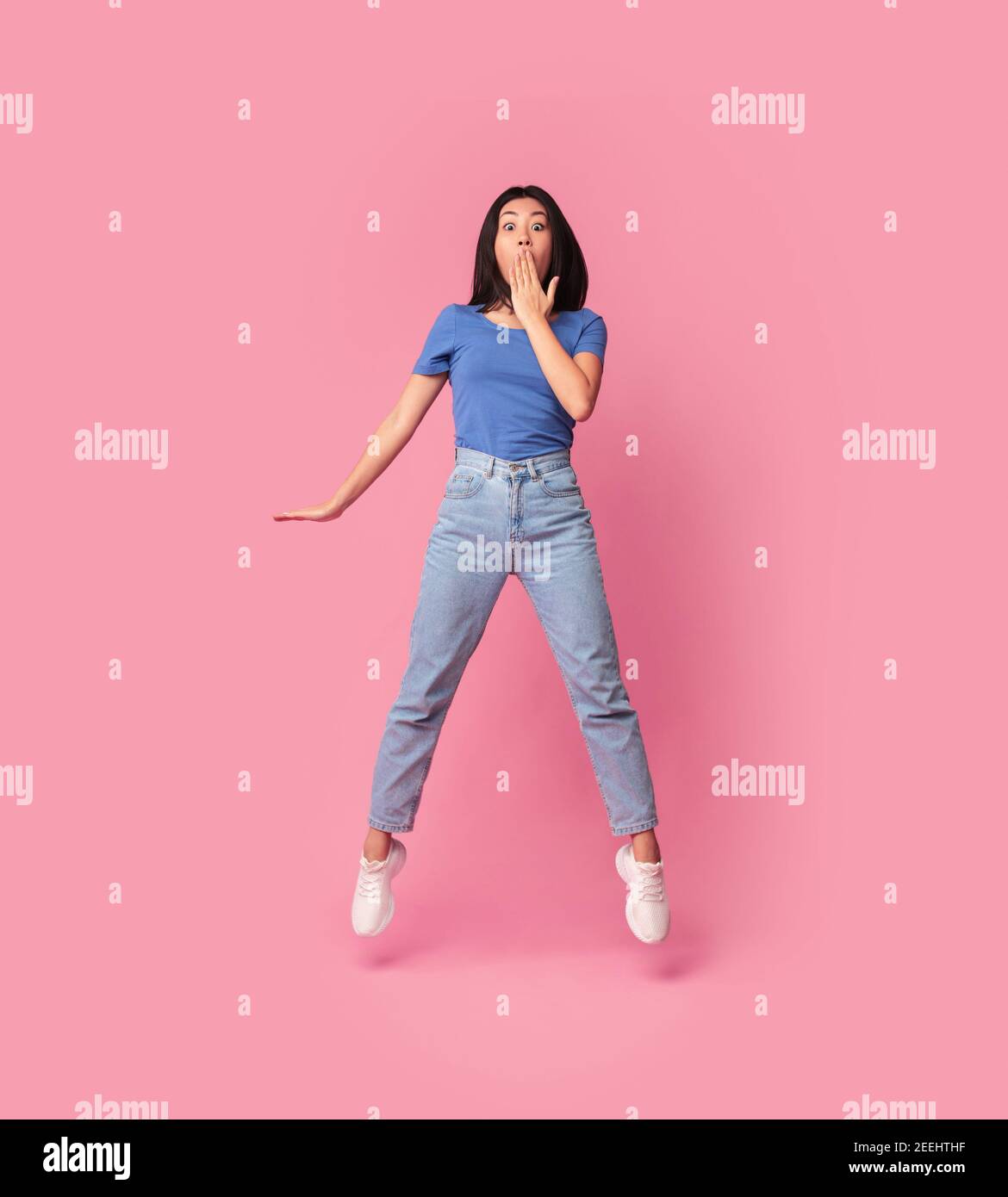 Surprised young asian woman jumping staring at camera Stock Photo - Alamy