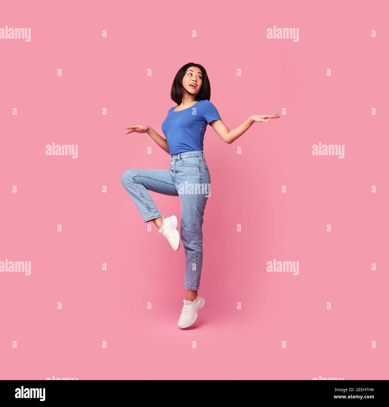 Happy young asian lady jumping at studio Stock Photo - Alamy