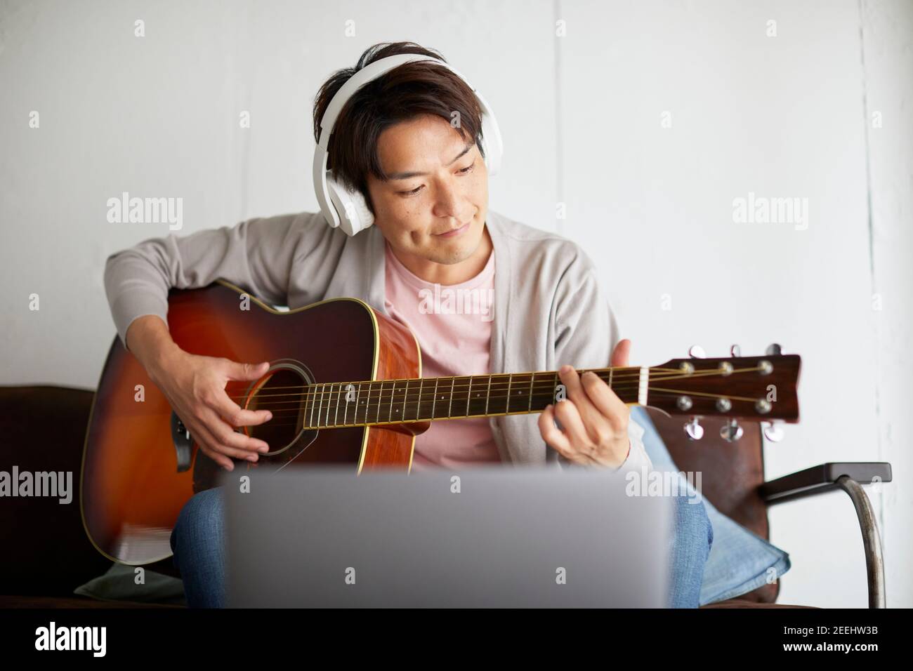 Japanese man playing guitar at home Stock Photo - Alamy