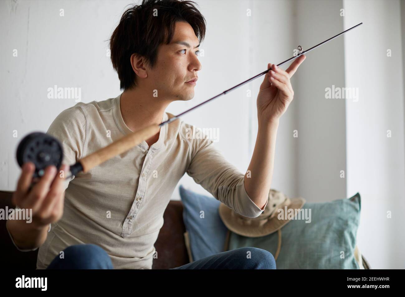 Japanese man cleaning fishing rod at home Stock Photo - Alamy