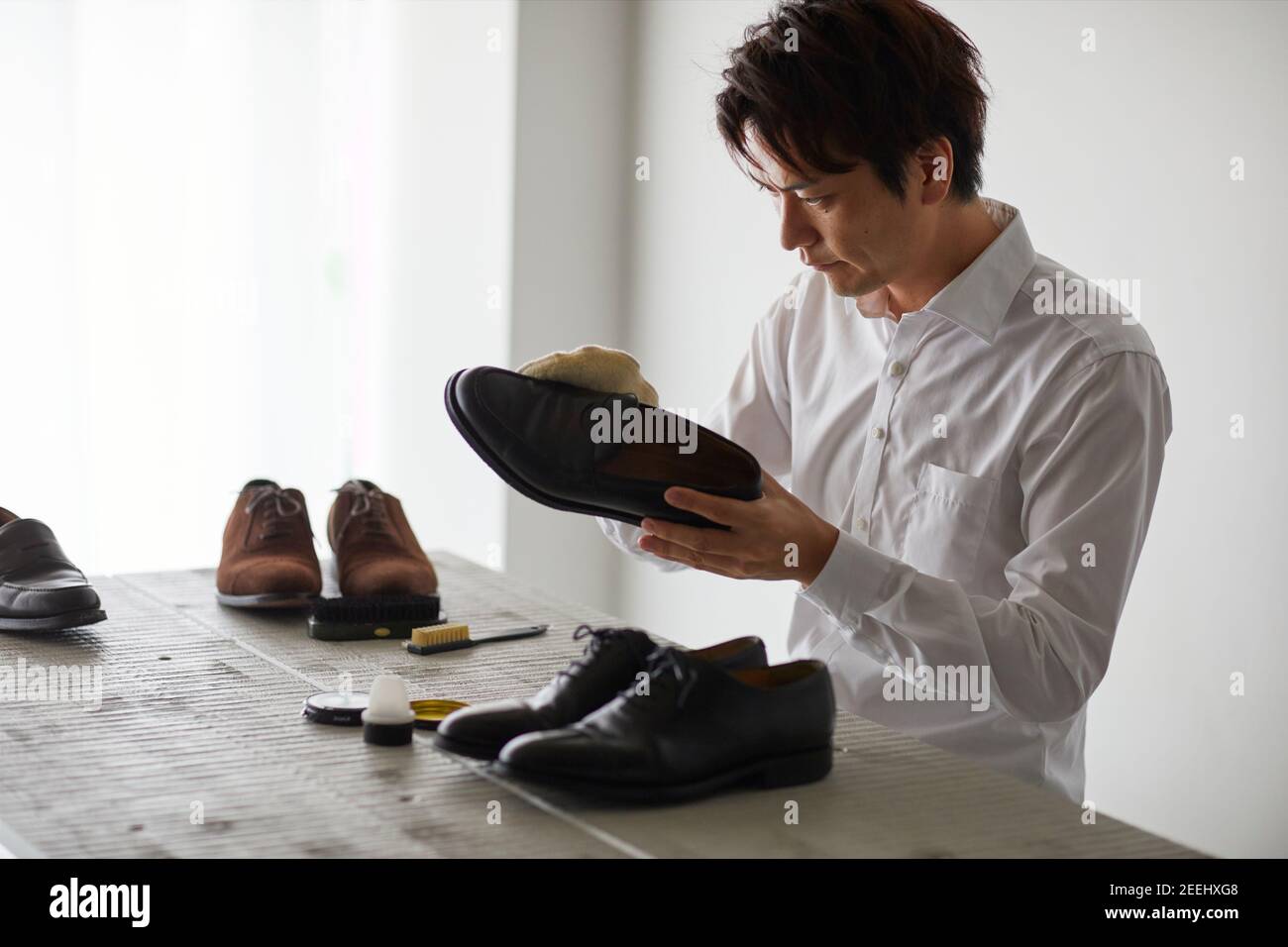 Japanese man cleaning shoes at home Stock Photo - Alamy