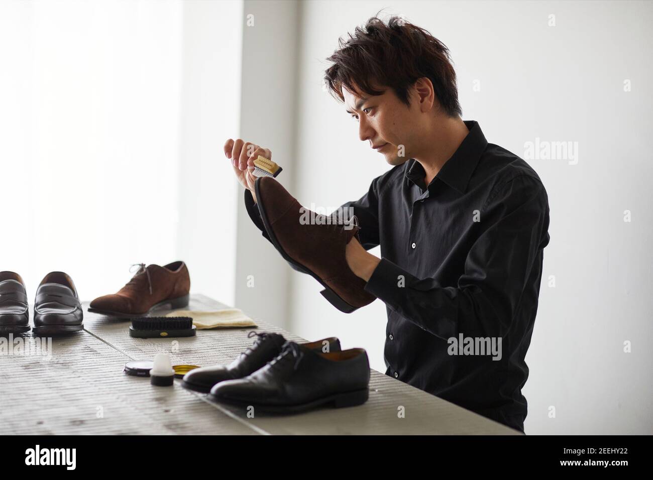 Japanese man cleaning shoes at home Stock Photo - Alamy
