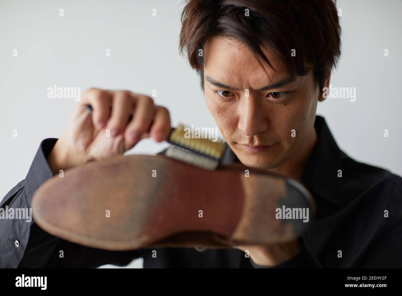 Japanese man cleaning shoes at home Stock Photo - Alamy