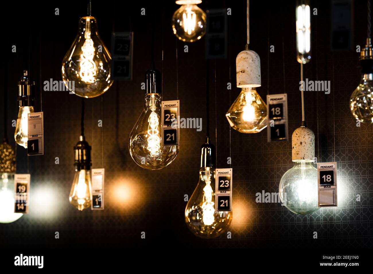 Light bulbs hanging down from ceiling in a shop Stock Photo - Alamy