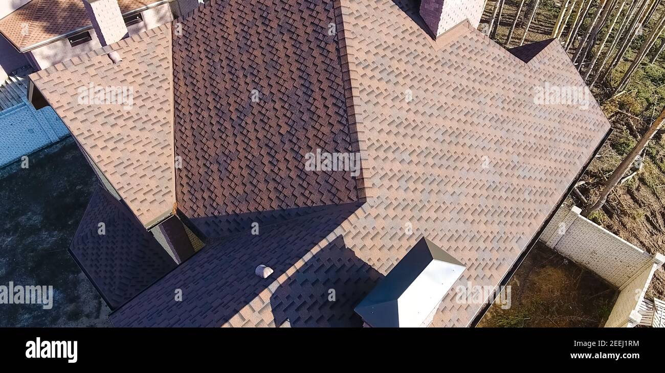 House with a roof from a bituminous tile. Bituminous tile for a roof. a ...
