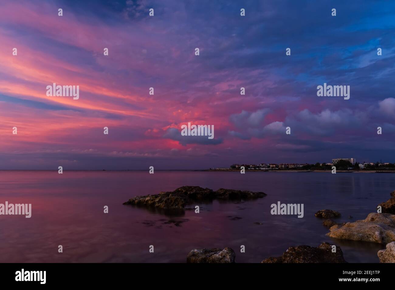 Pink sunset on the sea. Bright juicy landscape with low cumulus clouds ...