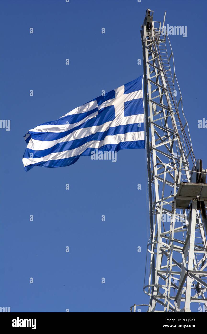 Vertical shot of the Greek flag hanging from a cell tower waving in the ...