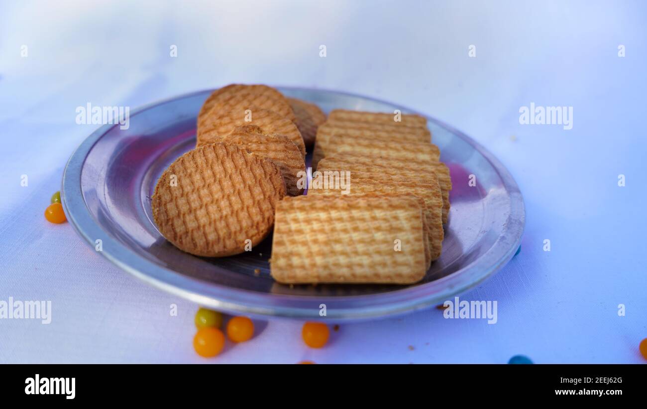 Different types of sweet cookies on plate and colorful candy isolated ...