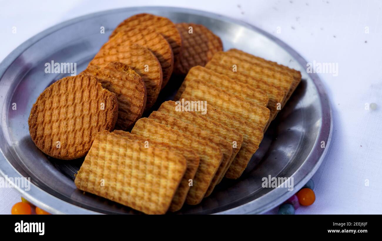 Different types of sweet cookies on plate and colorful candy isolated ...