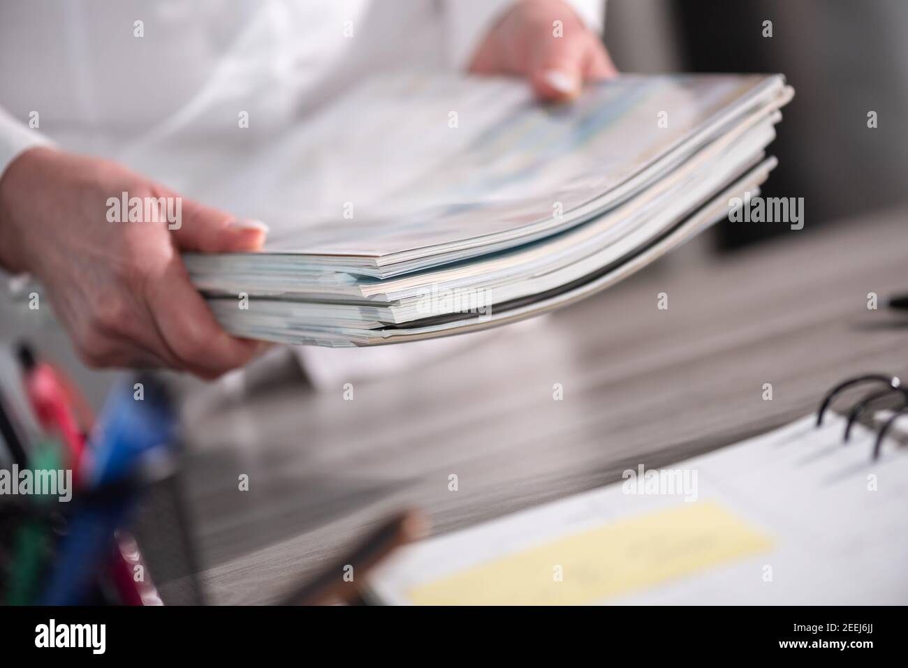 Female hands holding a stack of magazines Stock Photo - Alamy