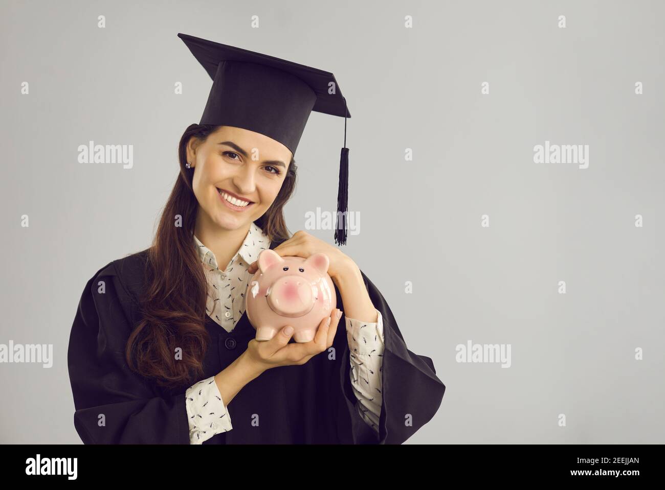 Copy space background with happy student holding piggy bank and smiling ...