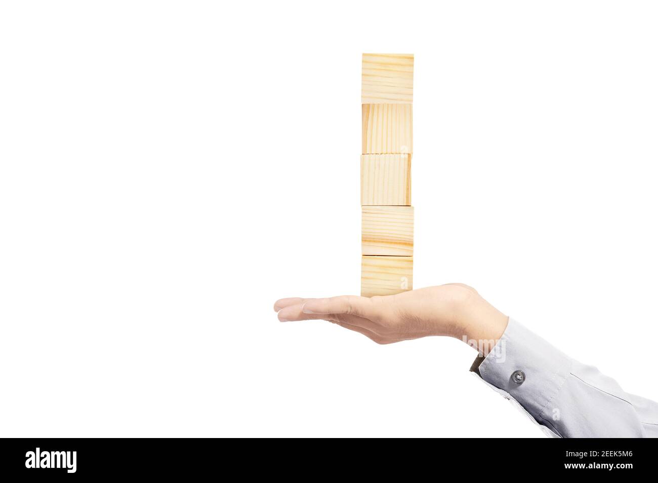 Hand holding stack of wooden block toy isolated over white background ...