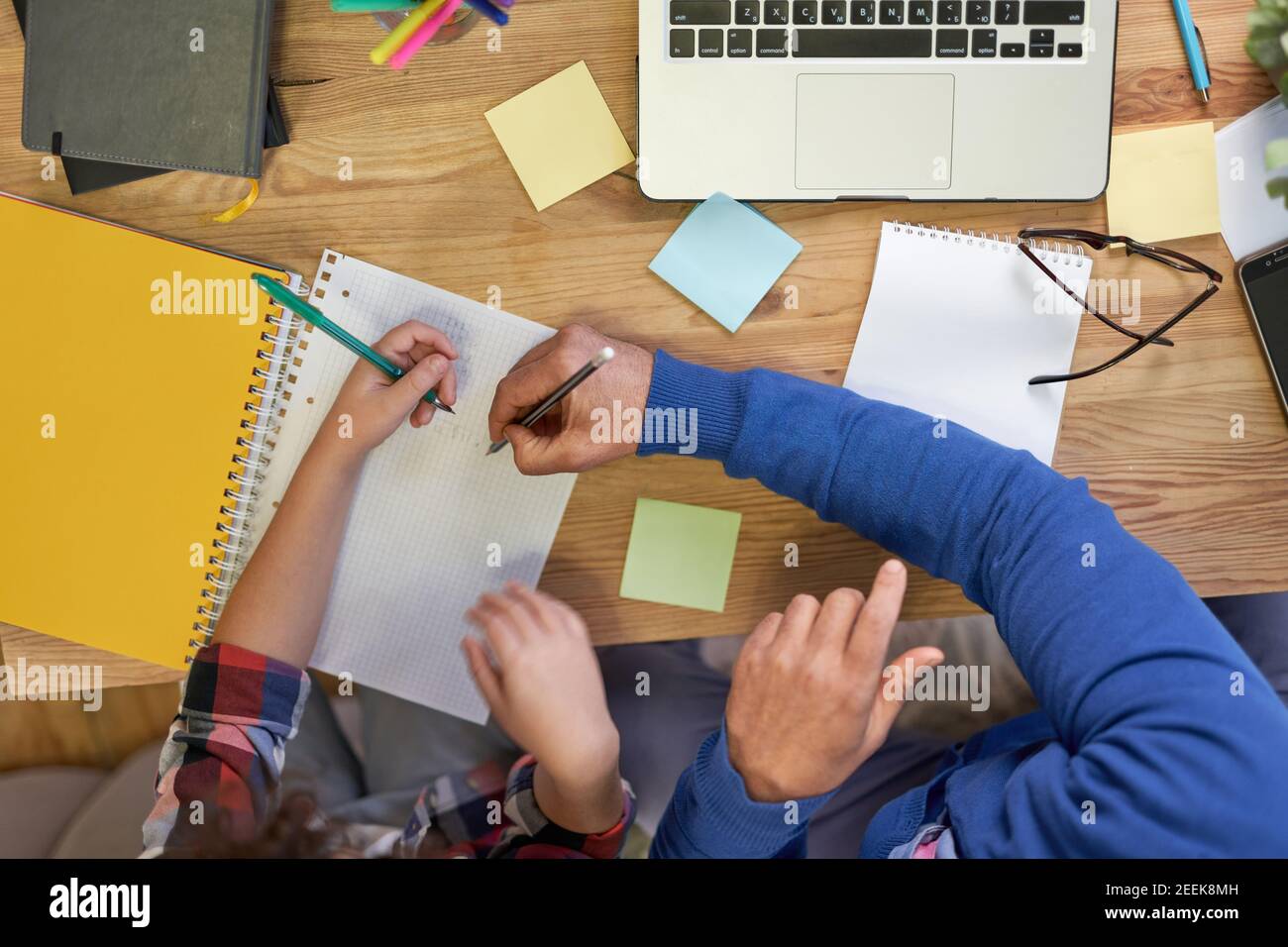 Top view of caring latin father helping his son with homework ...