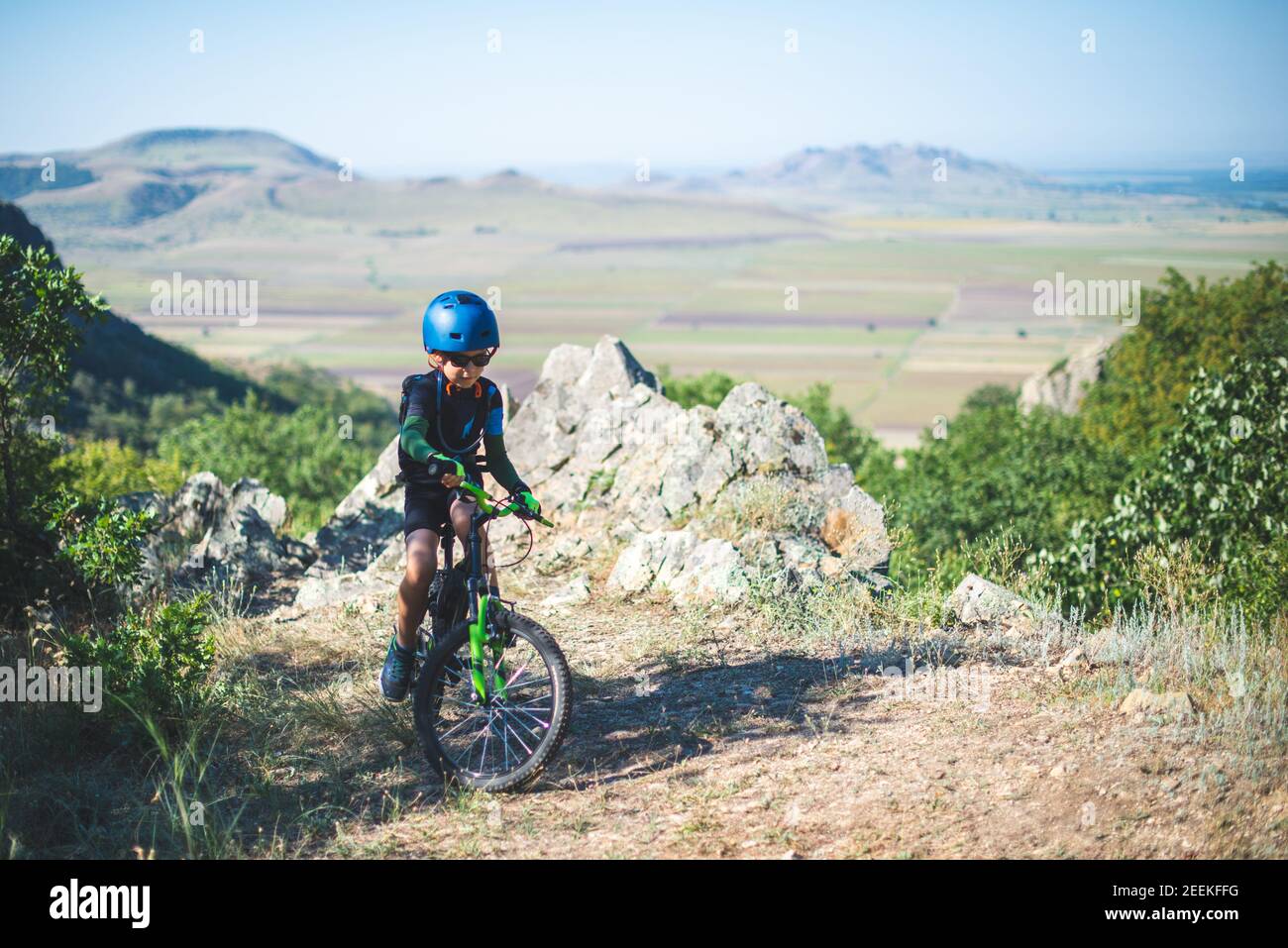 Happy kid boy of 8 years having fun in summer park with a bicycle on ...